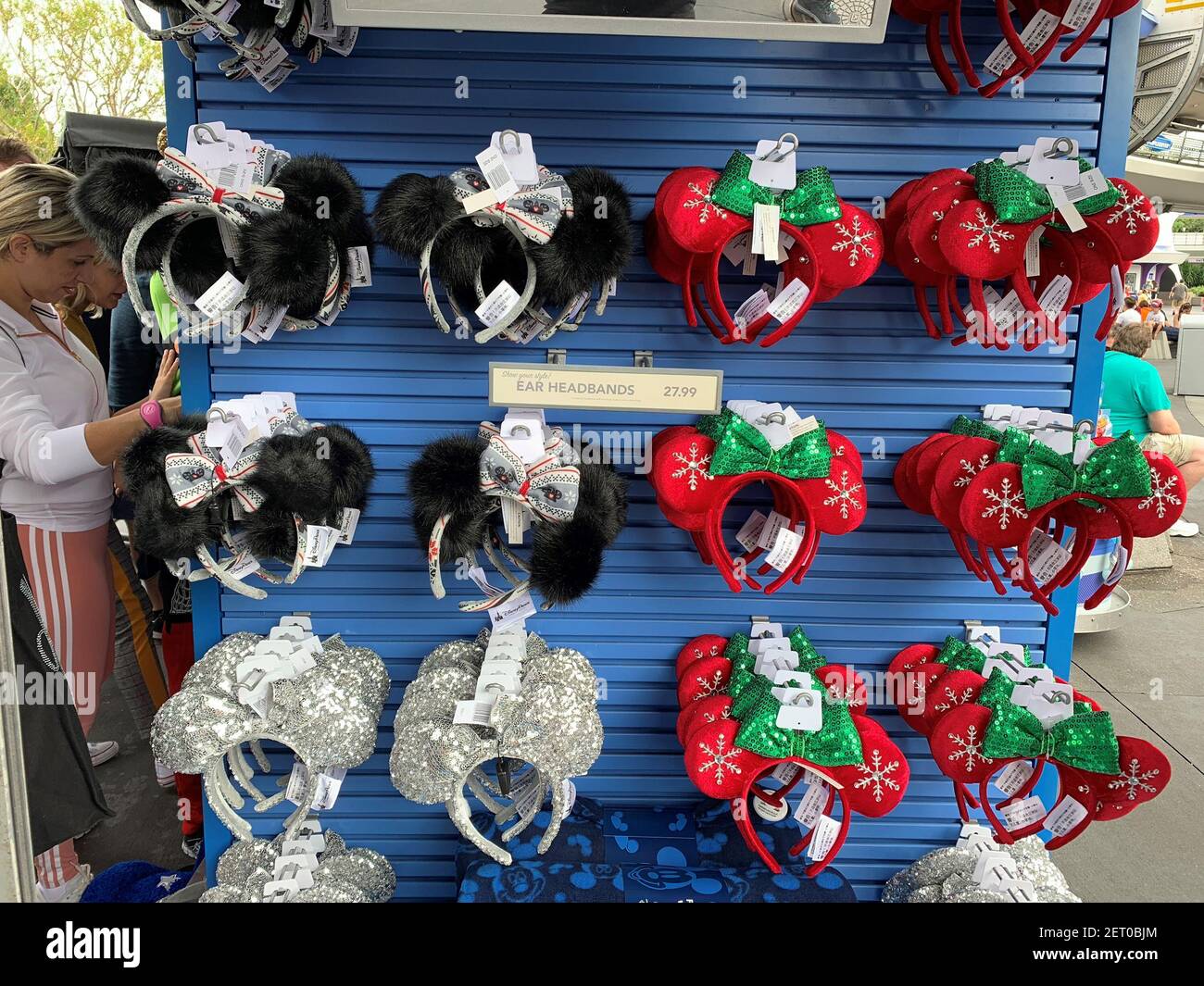 Magic Kingdom shoppers look over holiday-themed headbands, which come ...
