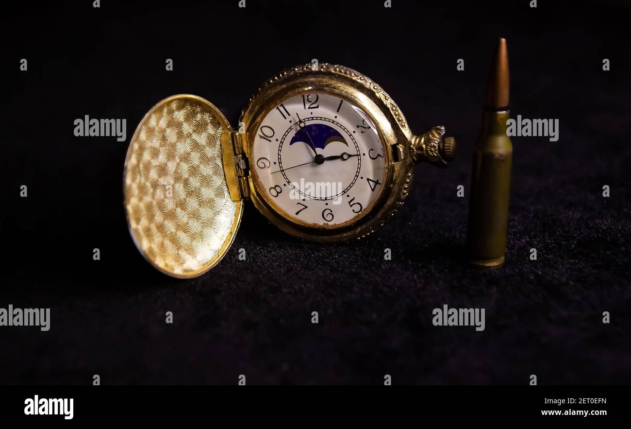 retro watch and bullets on black background, bullets and the watch on ...