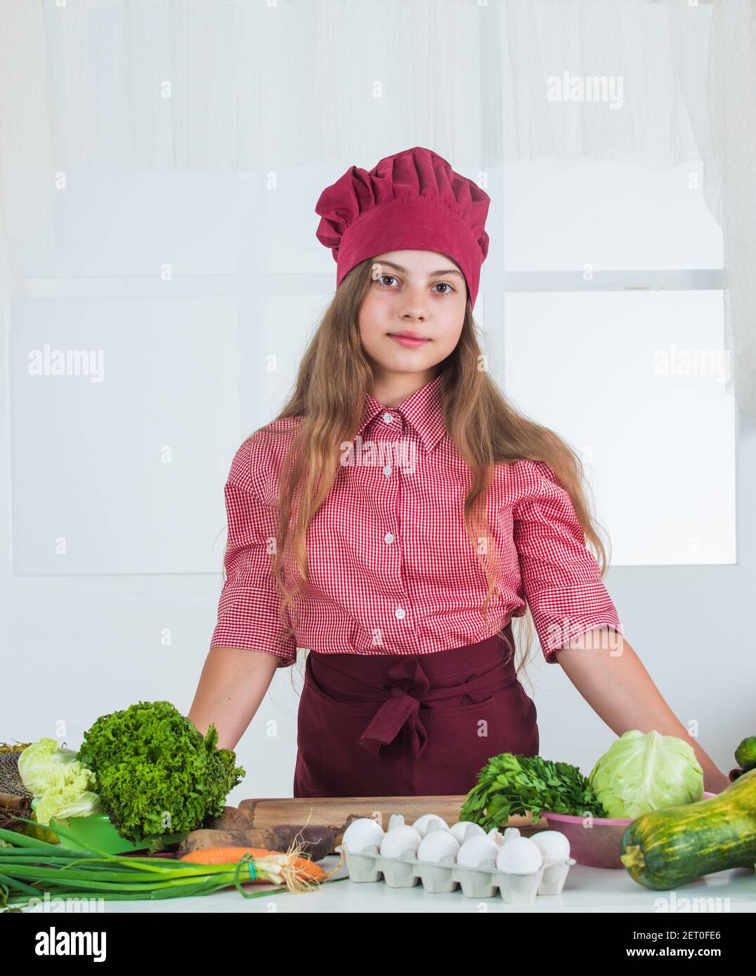 smiling teen girl in chef uniform cooking vegetables, vegetarian Stock ...
