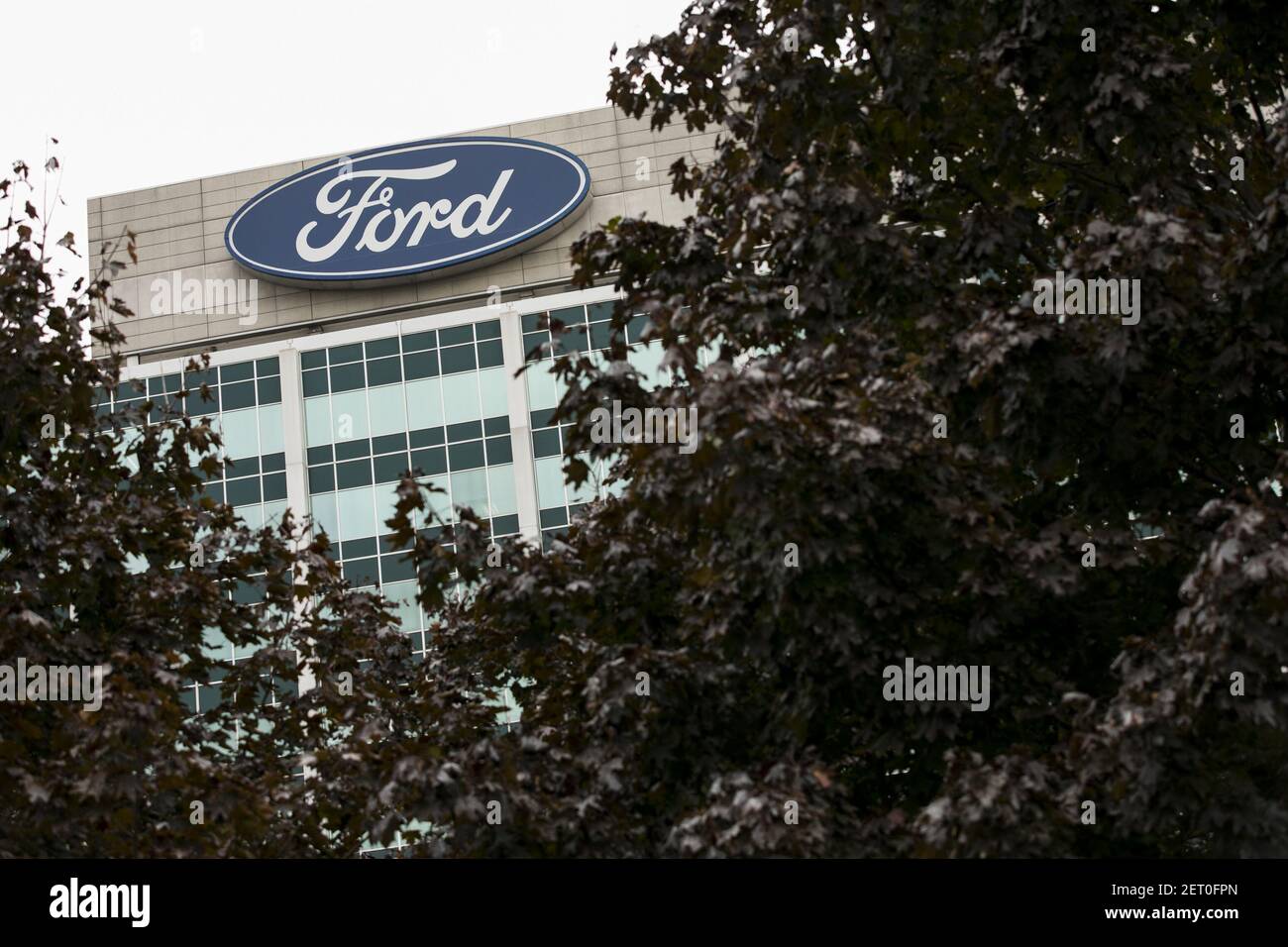 A logo sign outside of the headquarters of the Ford Motor Company in ...