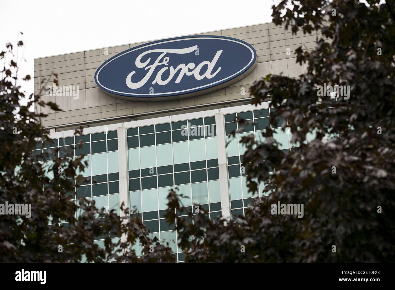 A logo sign outside of the headquarters of the Ford Motor Company in ...