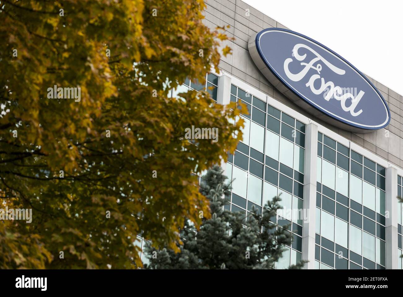 A logo sign outside of the headquarters of the Ford Motor Company in ...