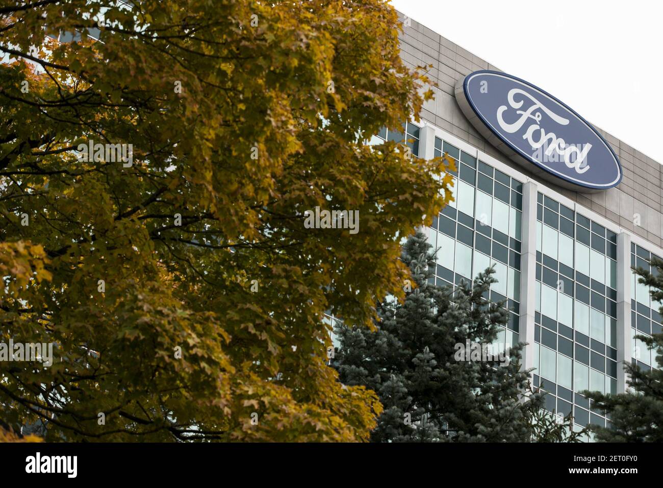 A logo sign outside of the headquarters of the Ford Motor Company in ...