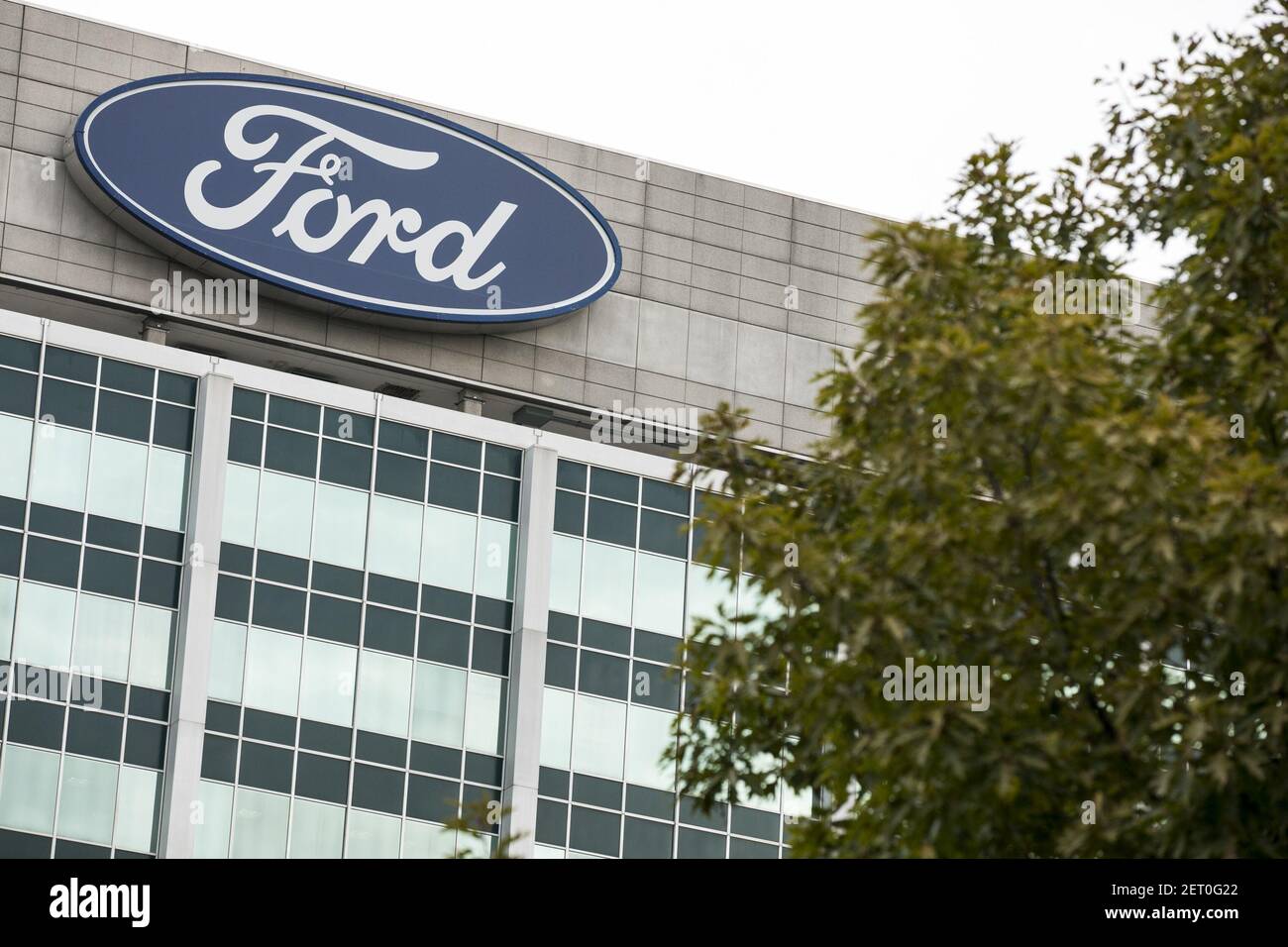 A logo sign outside of the headquarters of the Ford Motor Company in ...