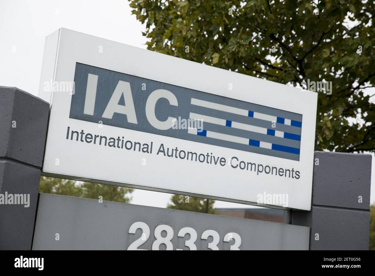 A logo sign outside of a facility occupied by International Automotive ...
