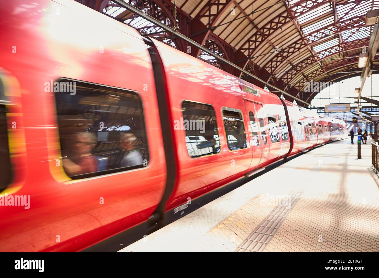 A train at a train-station going fast Stock Photo - Alamy
