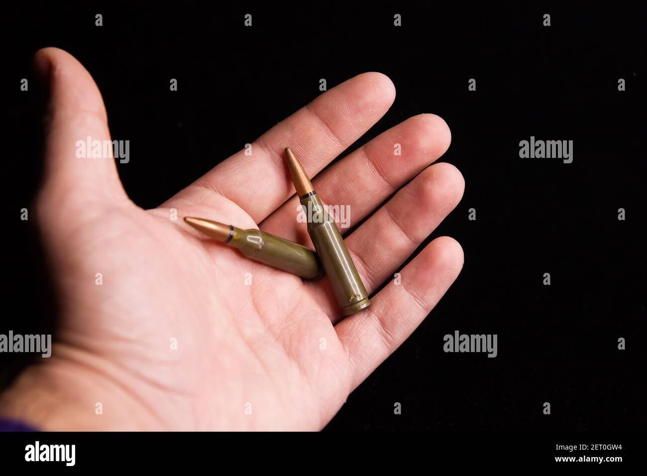 bullets in a hand, hand holding a bullet on black background Stock ...