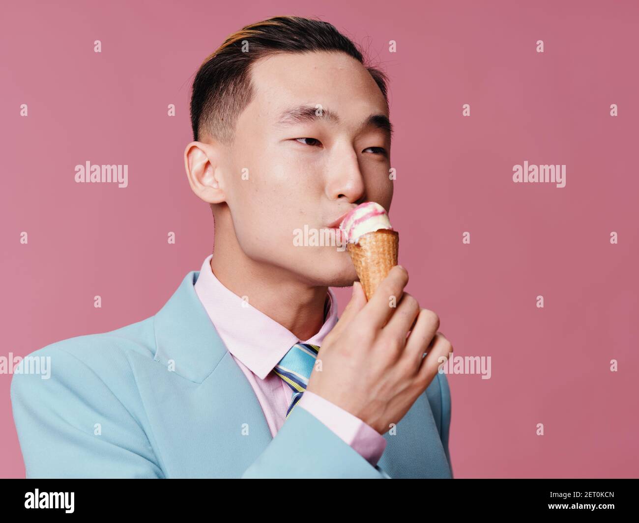 Man eating ice cream lifestyle pink background close-up Stock Photo - Alamy