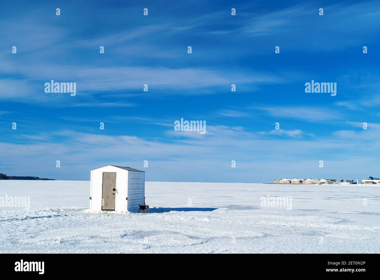 Ice fishing on a frozen harbor along the coast of Prince Edward Island ...