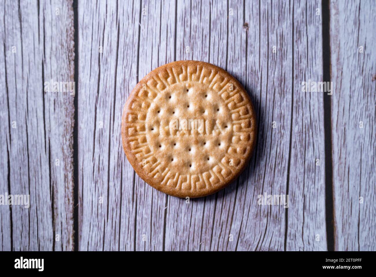 A top view of a fresh Maria cookie (galleta Maria) on a wooden sur ...