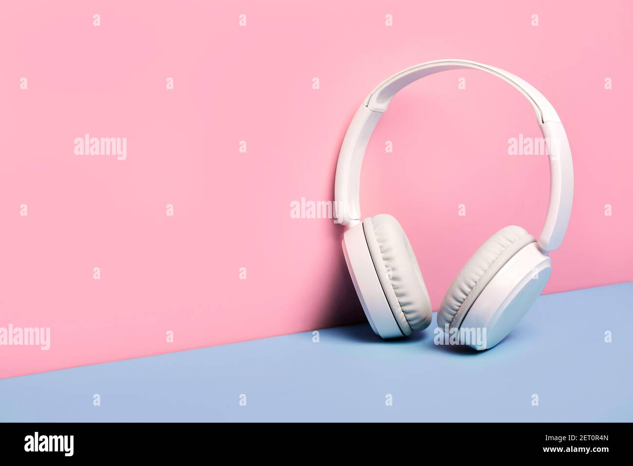 White bluetooth wireless headphone on pink and blue background Stock ...