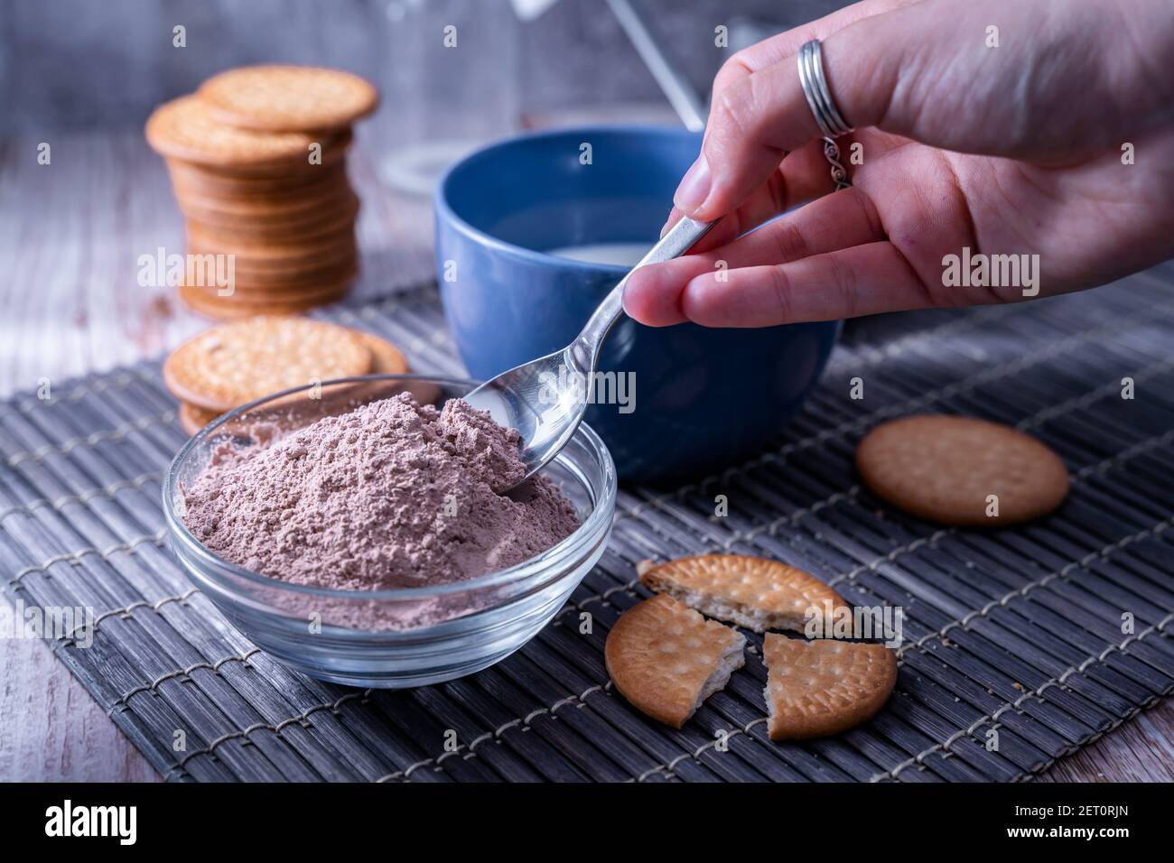 A hand making cocoa milk with powdered cocoa on the next to Maria ...