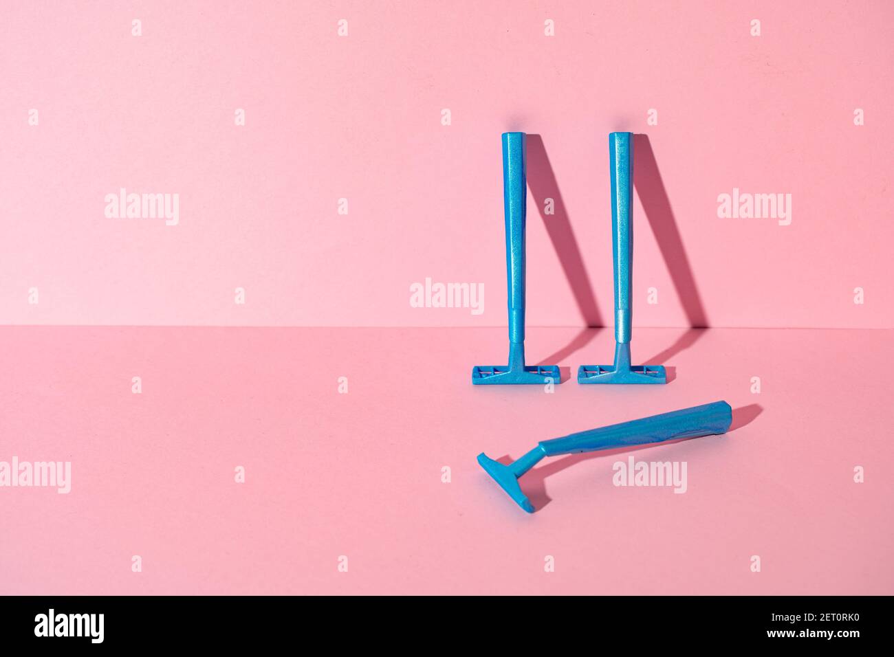 Blue disposable razors on pink paper background Stock Photo - Alamy