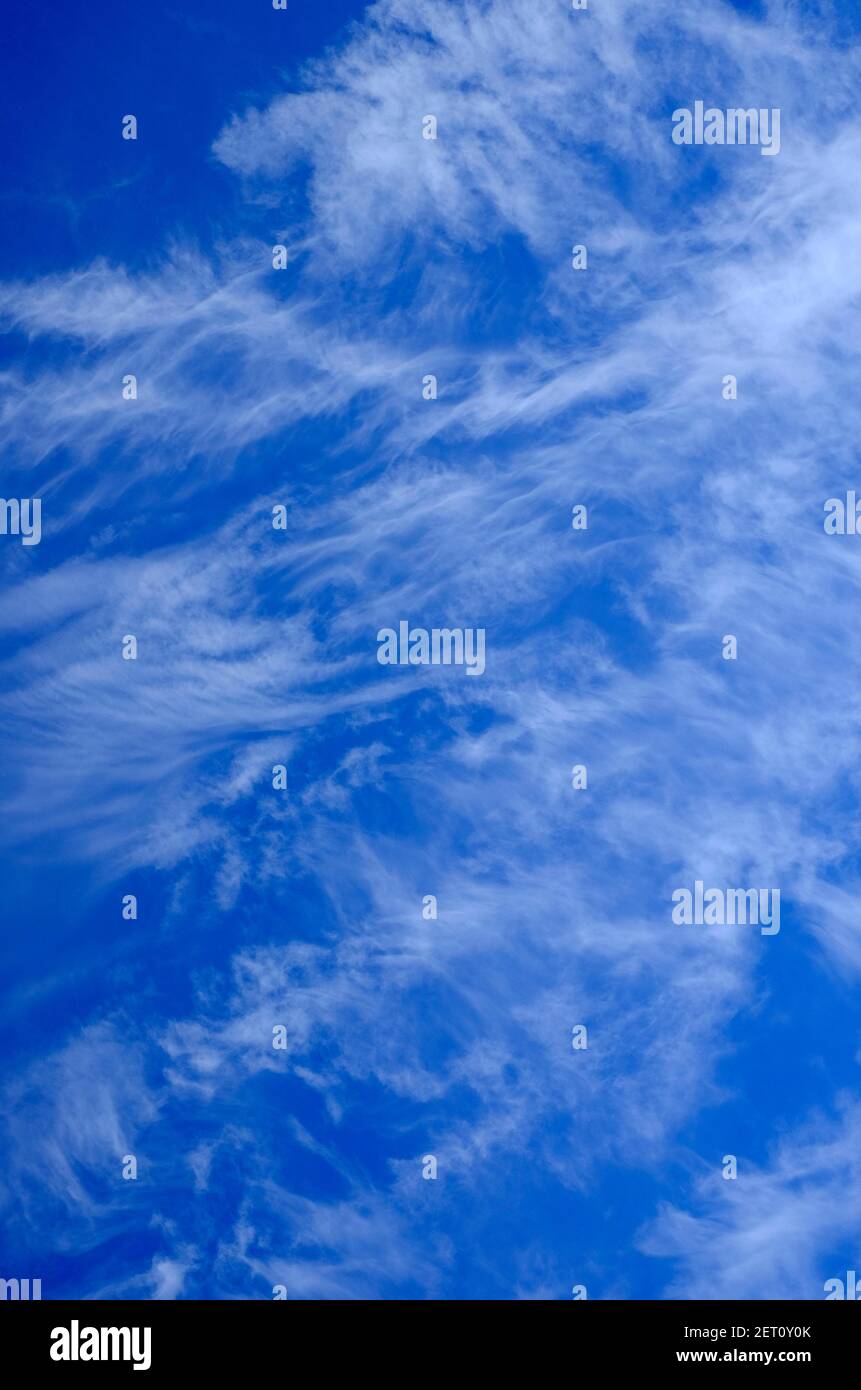 wispy white clouds on bright blue winter sky background Stock Photo - Alamy