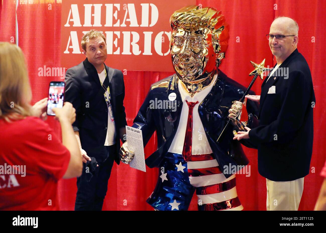 Attendees are photographed with the wildly popular 'Golden Don' statue ...