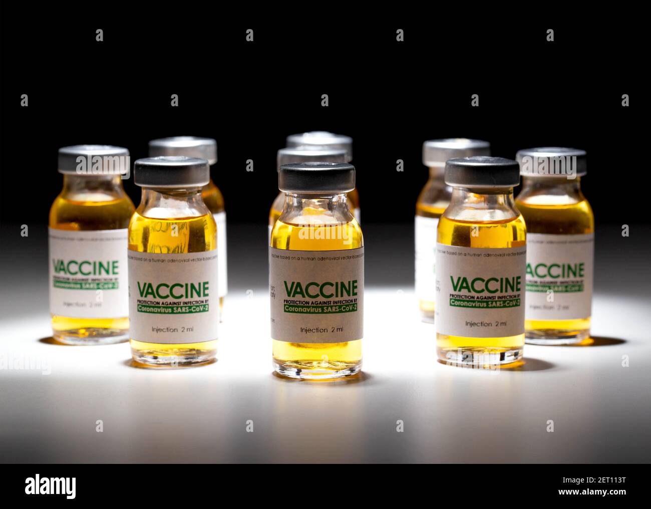 Vials of coronavirus vaccine stand in a circle on a black background ...