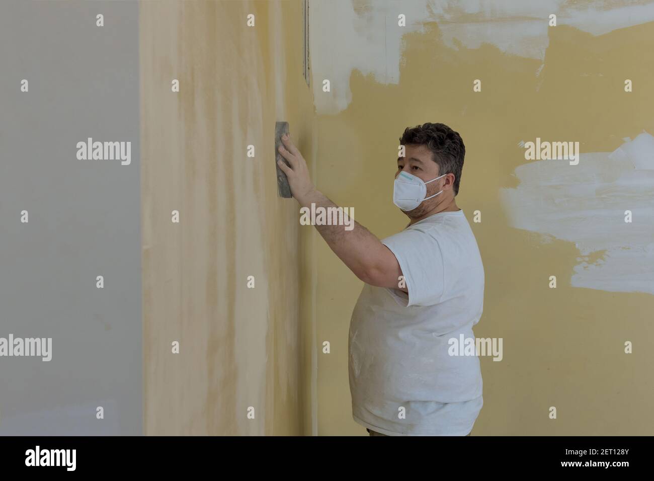 Contractor using sand trowel sanding the the plaster plasterboard ...