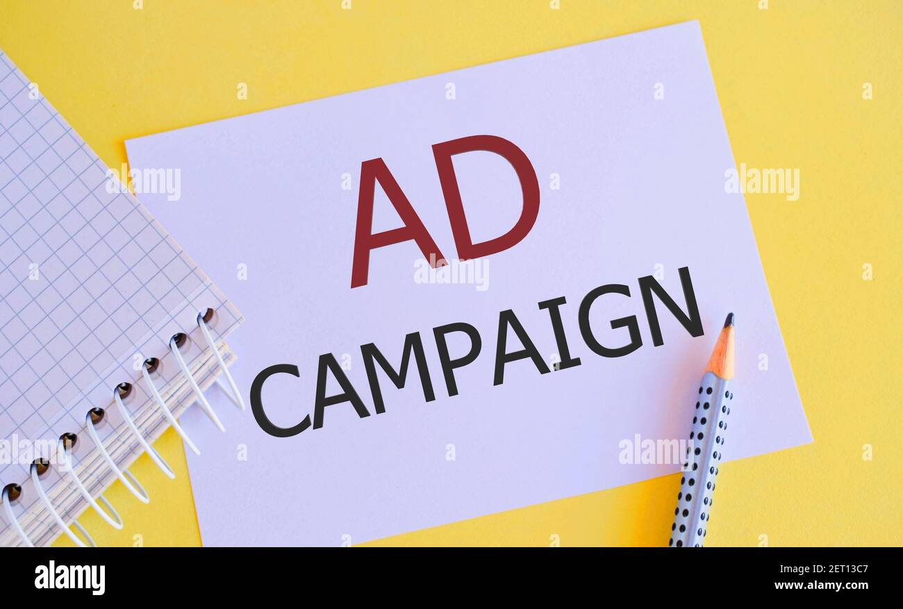 Ad Campaign text written on white paper above yellow background.Concept ...