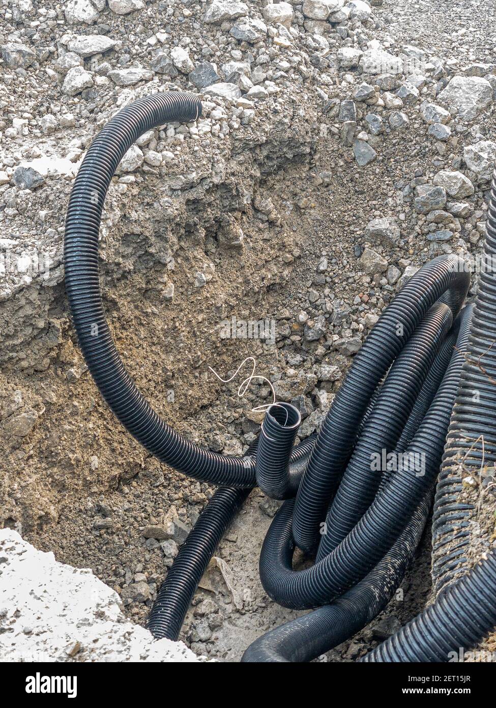 Empty pipes lie in a pit in the earth Stock Photo - Alamy