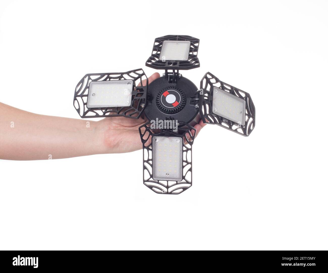 Man holds in hand an illuminating garage spotlight on a white ...