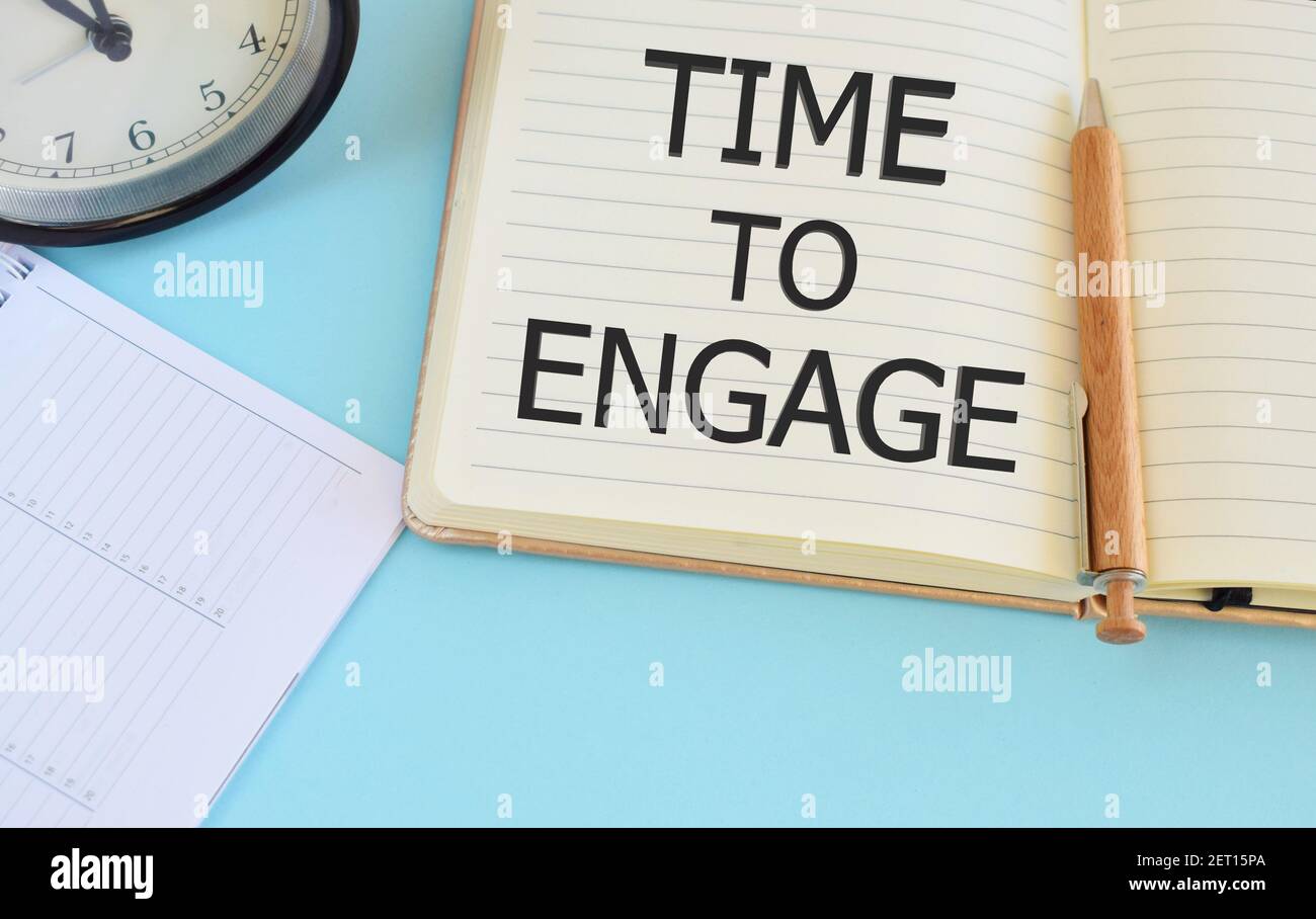 Time to engage text written in Notebook. Lightblue background. Business ...