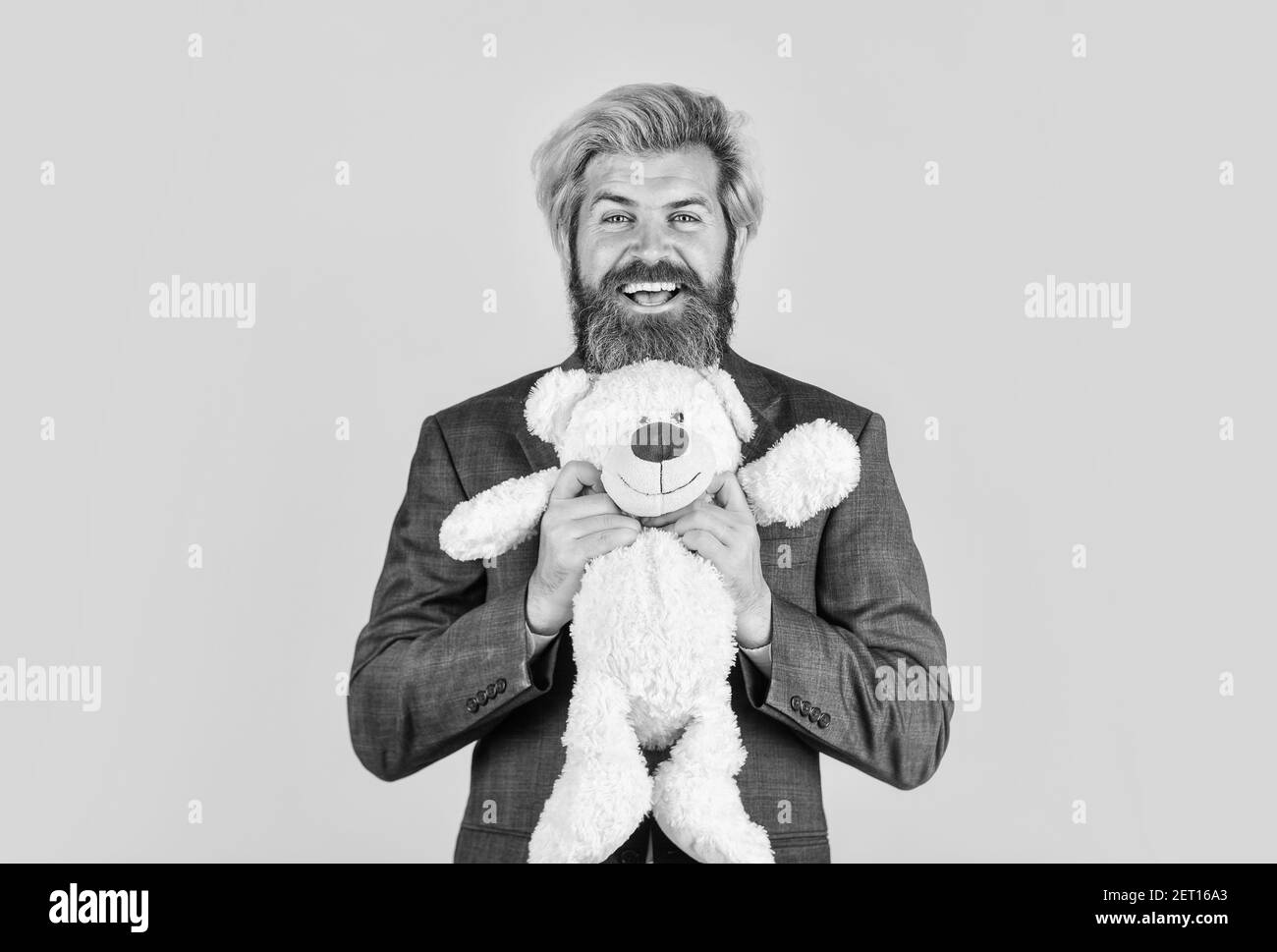 Still childish in soul. Happy businessman hug teddy bear yellow ...