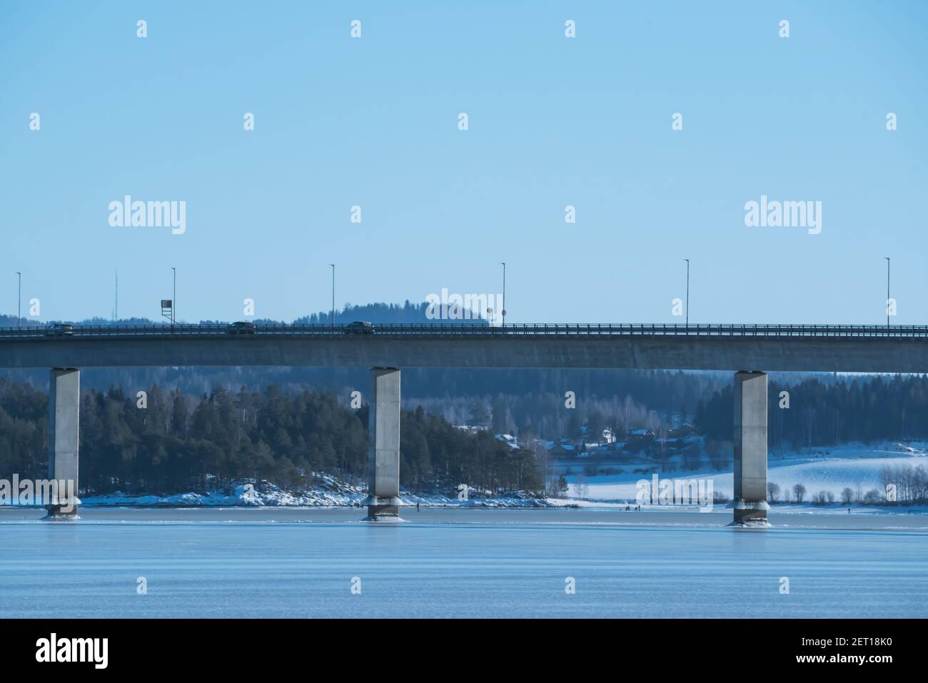 Highway bridge with traffic driving on it, spanning across a frozen bay ...