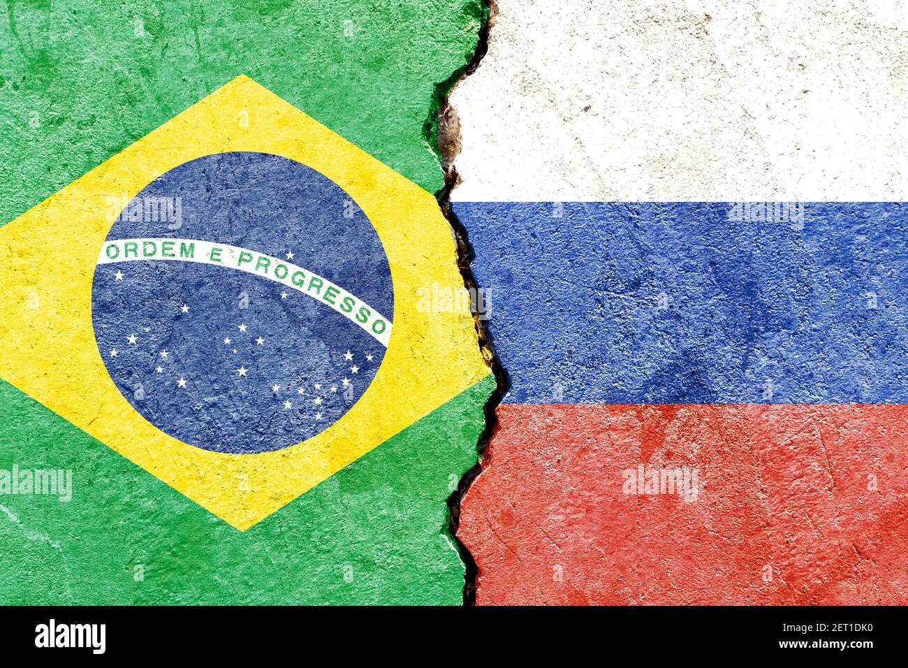 A top view of a cracked stone painted with the flags of Brazil and ...