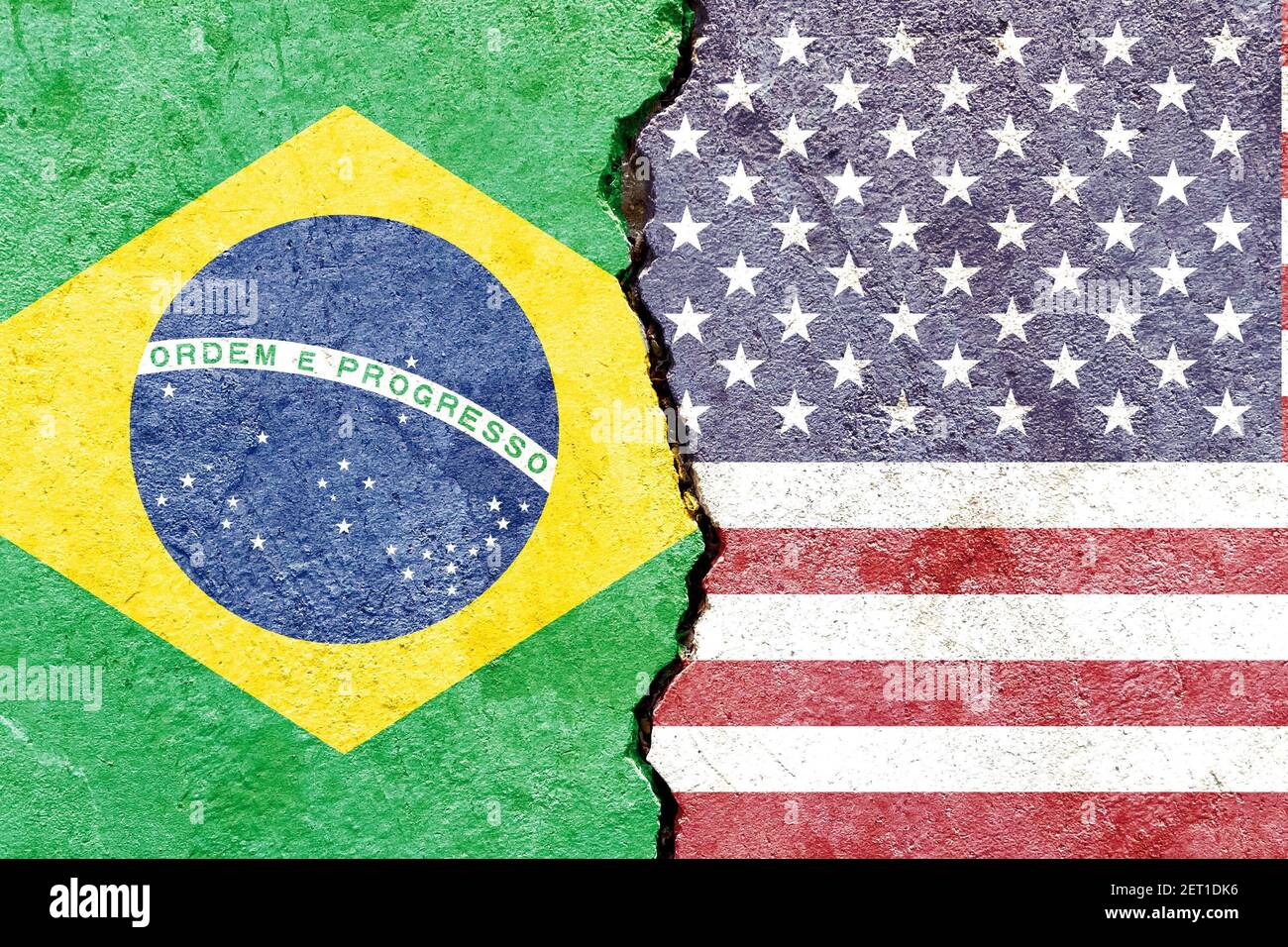 A top view of a cracked stone painted with the flags of Brazil and USA ...