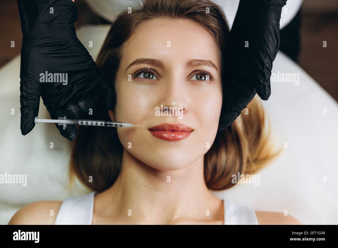 Injections beauty treatment. Close-up of a young woman s face lying on ...