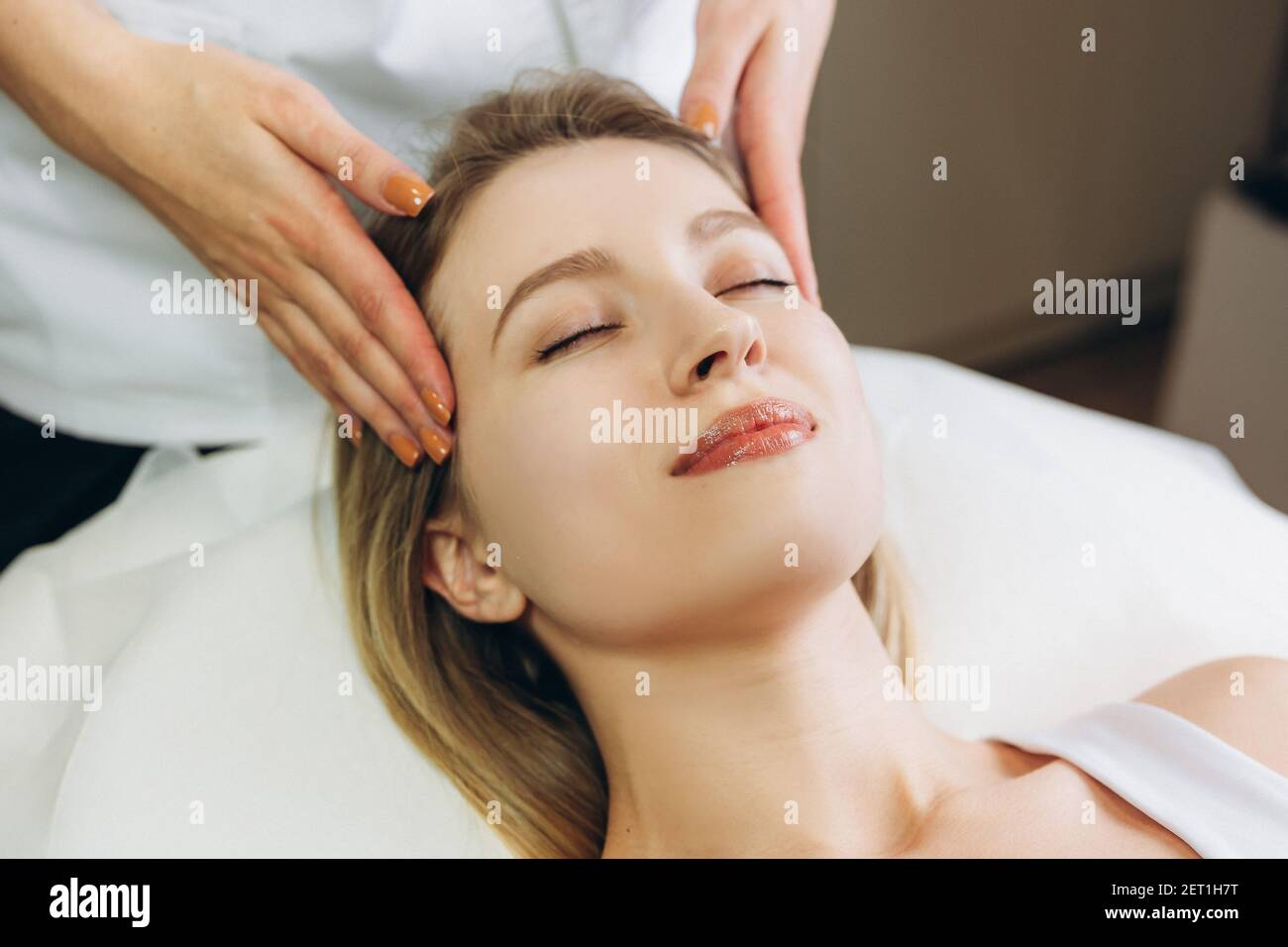 Facial massage beauty treatment. Close-up of a young woman s face lying ...