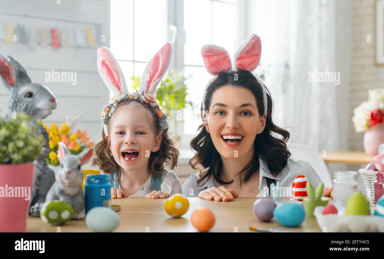 Mother and her daughter painting eggs. Happy family preparing for ...