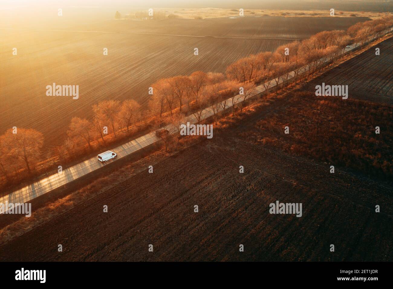 Aerial view of minivan on the road in sunset, drone pov high angel view ...