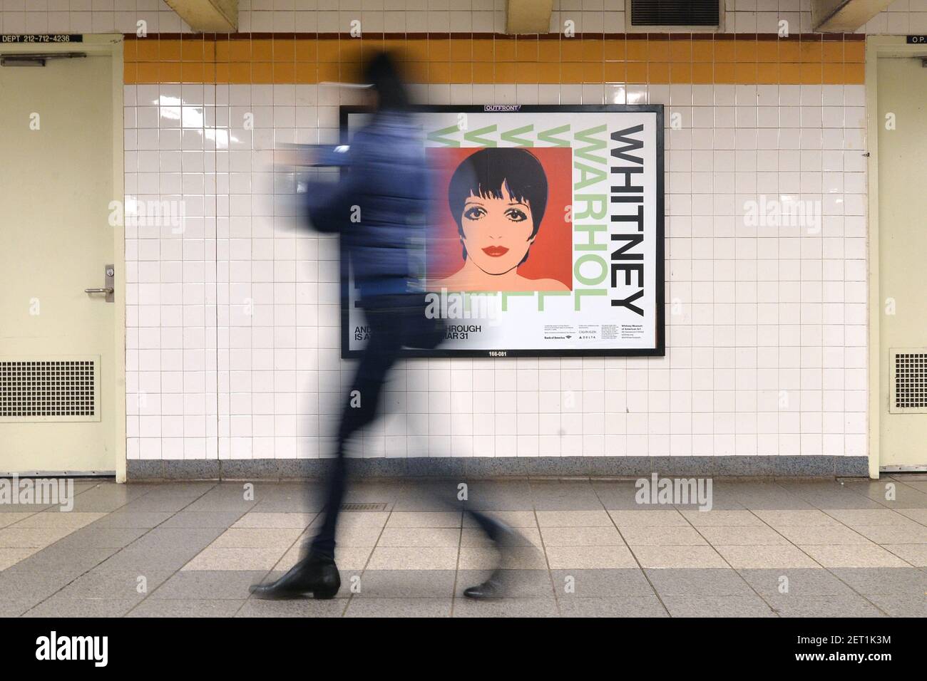A commuter walks past an Andy Warhol poster in the 14th Street and 8th ...