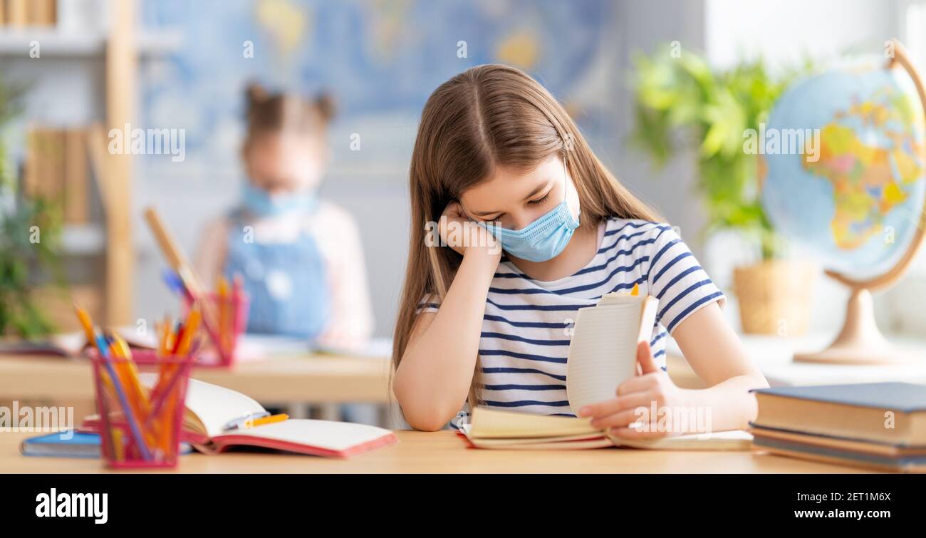 Back to school! Cute industrious children are sitting at desks indoors ...