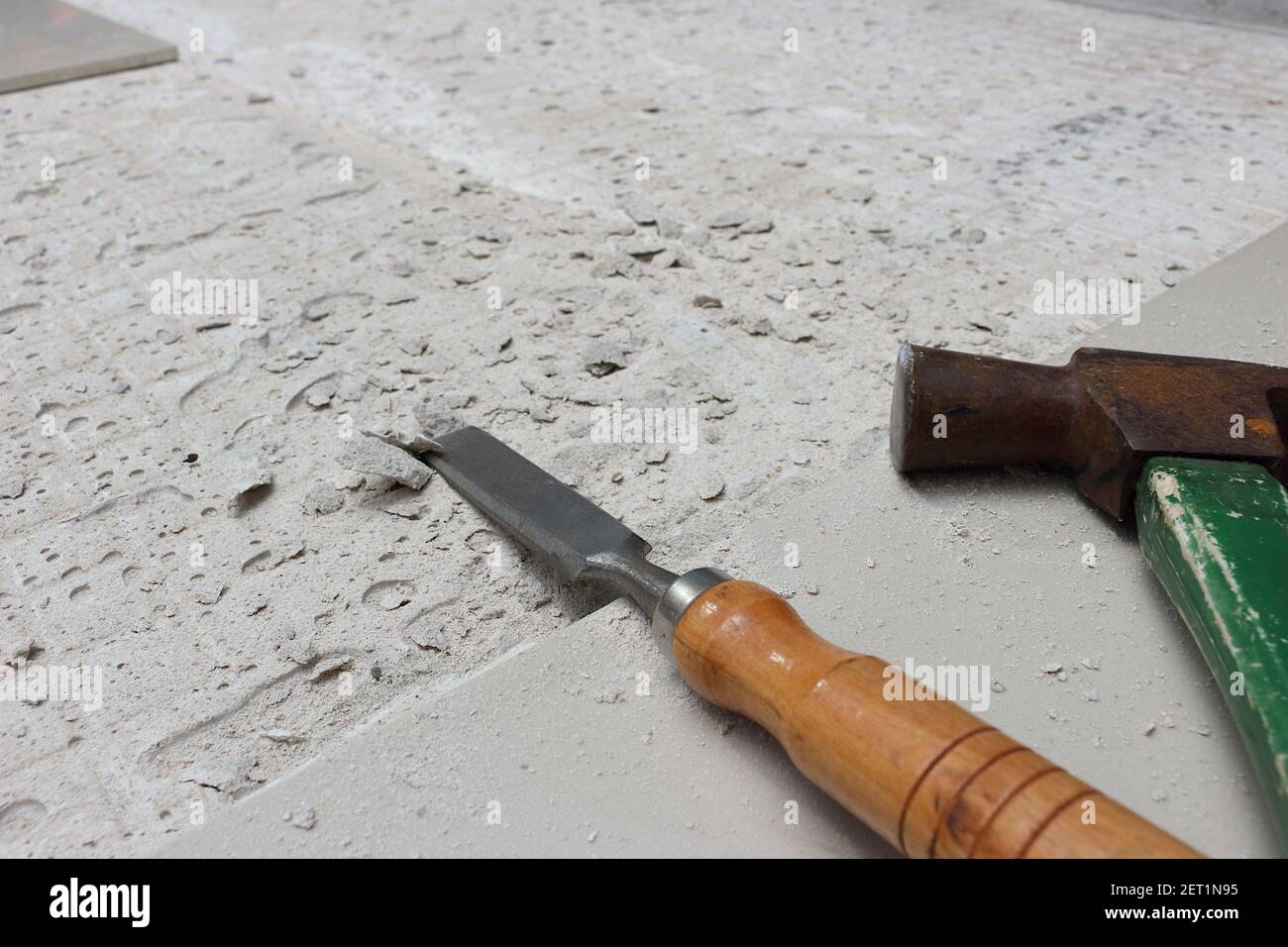 A hammer for hammering nails and a wood chisel is placed beside the ...
