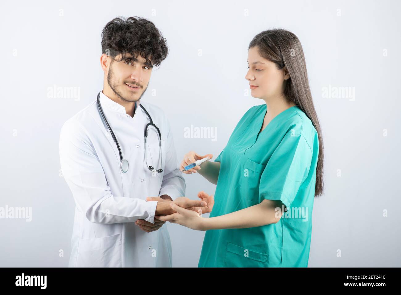 Female nurse in green uniform giving injection to male doctor. High ...
