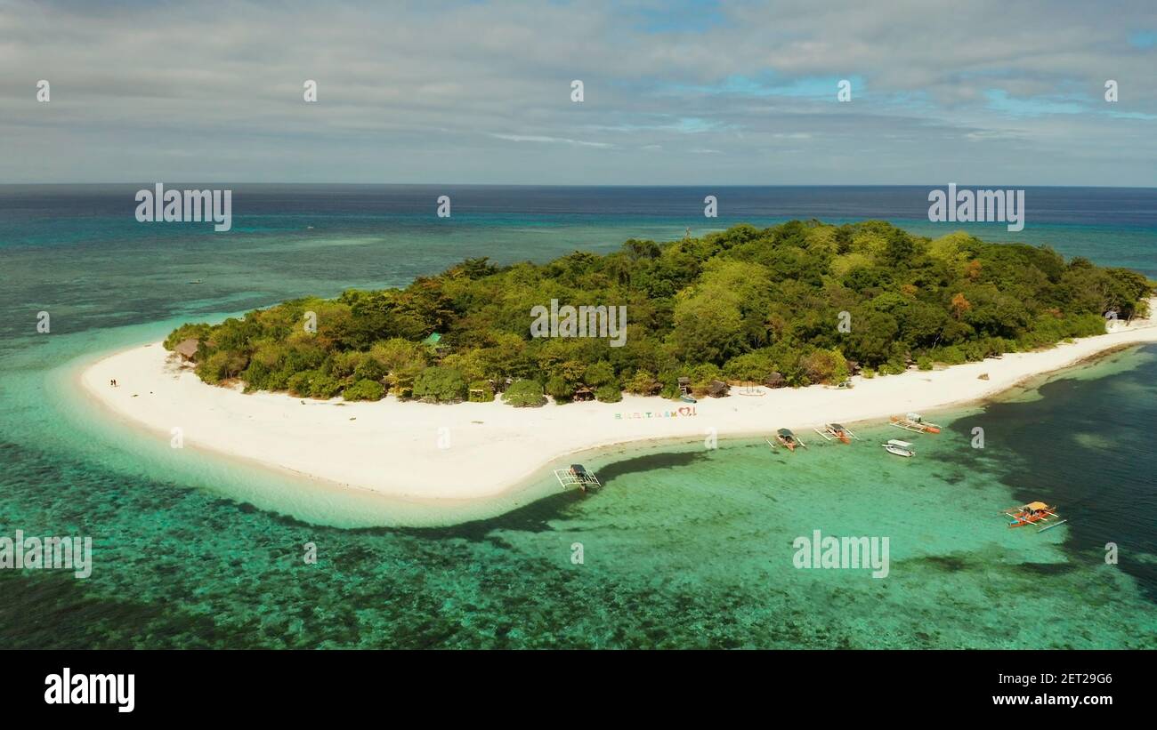 Tropical island Mantigue and sandy beach surrounded by atoll coral reef ...