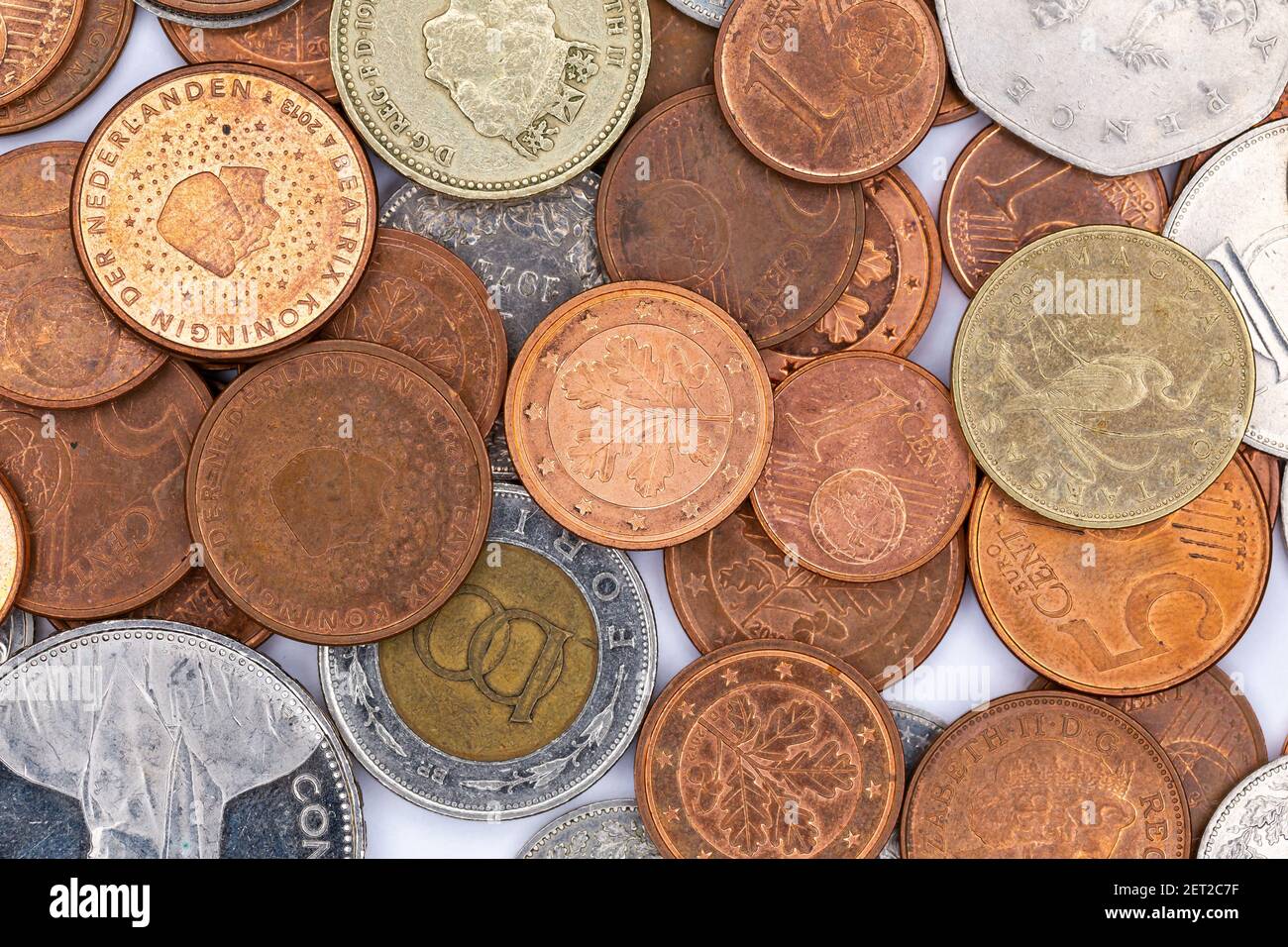 Layer of coins from different countries. Object illuminated with ...