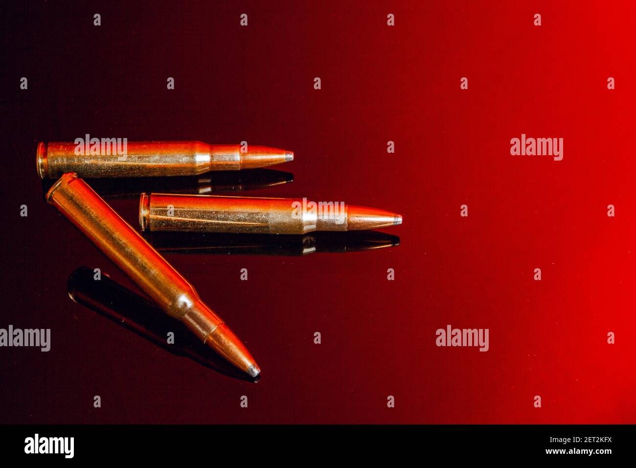 Rifle bullets or cartridges on black shiny background with red ...