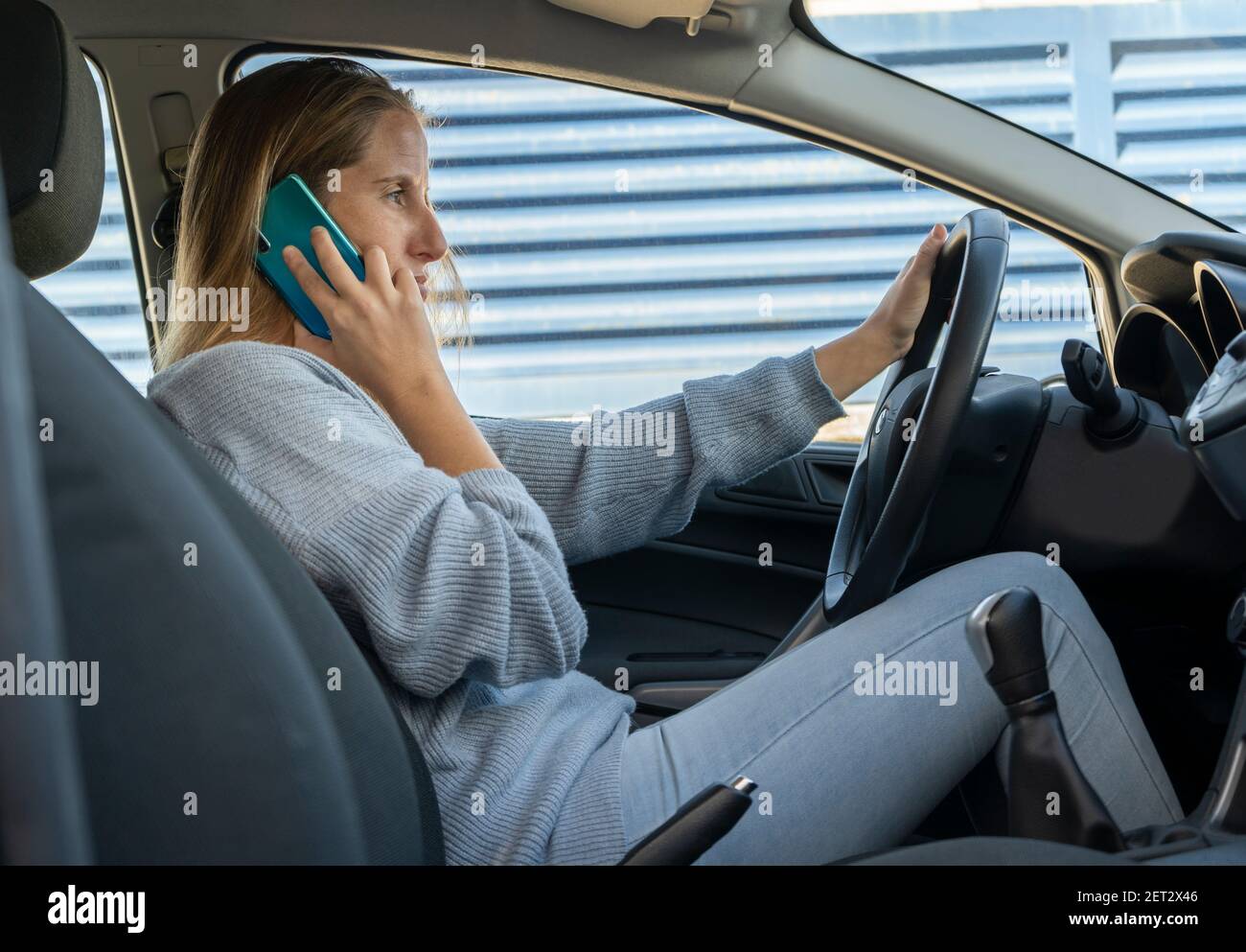 Young female calling and driving her car,dangerous concept .Woman using ...
