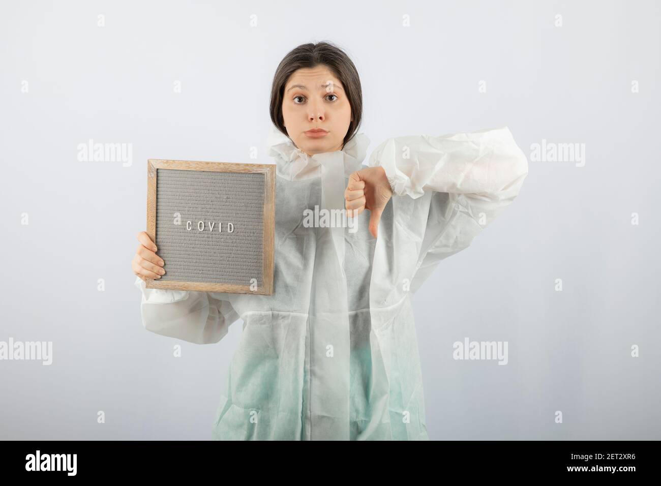 Female doctor in protective suit lab coat showing a thumb down Stock ...