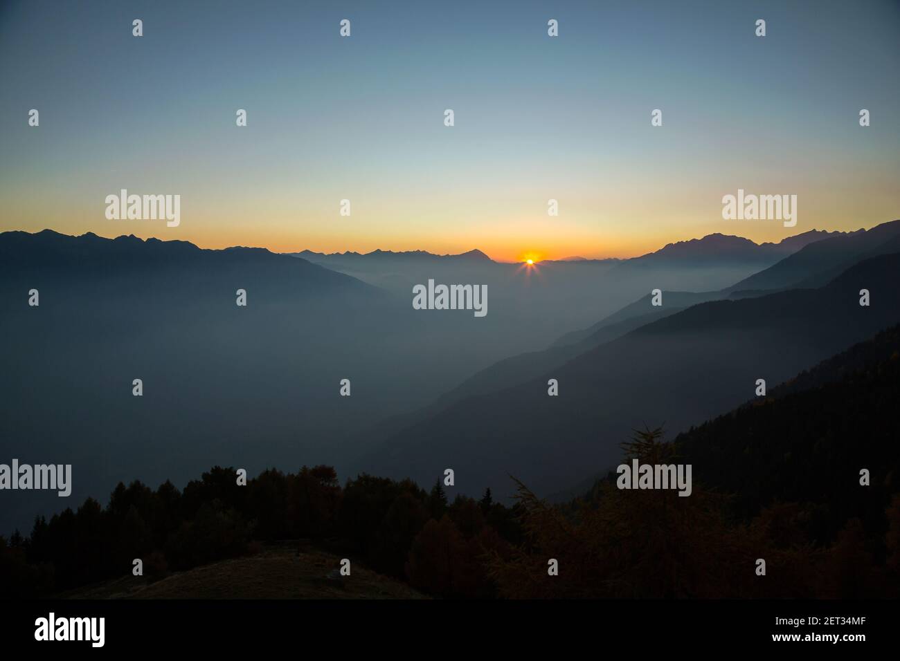 alpine sunset with sun and shadows Stock Photo - Alamy