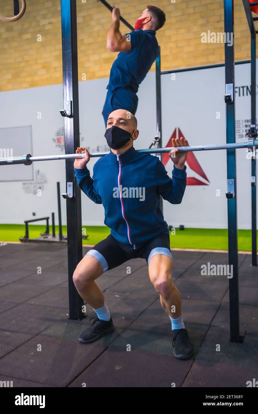 A view of Two athletes performing strength exercises in the gym during ...