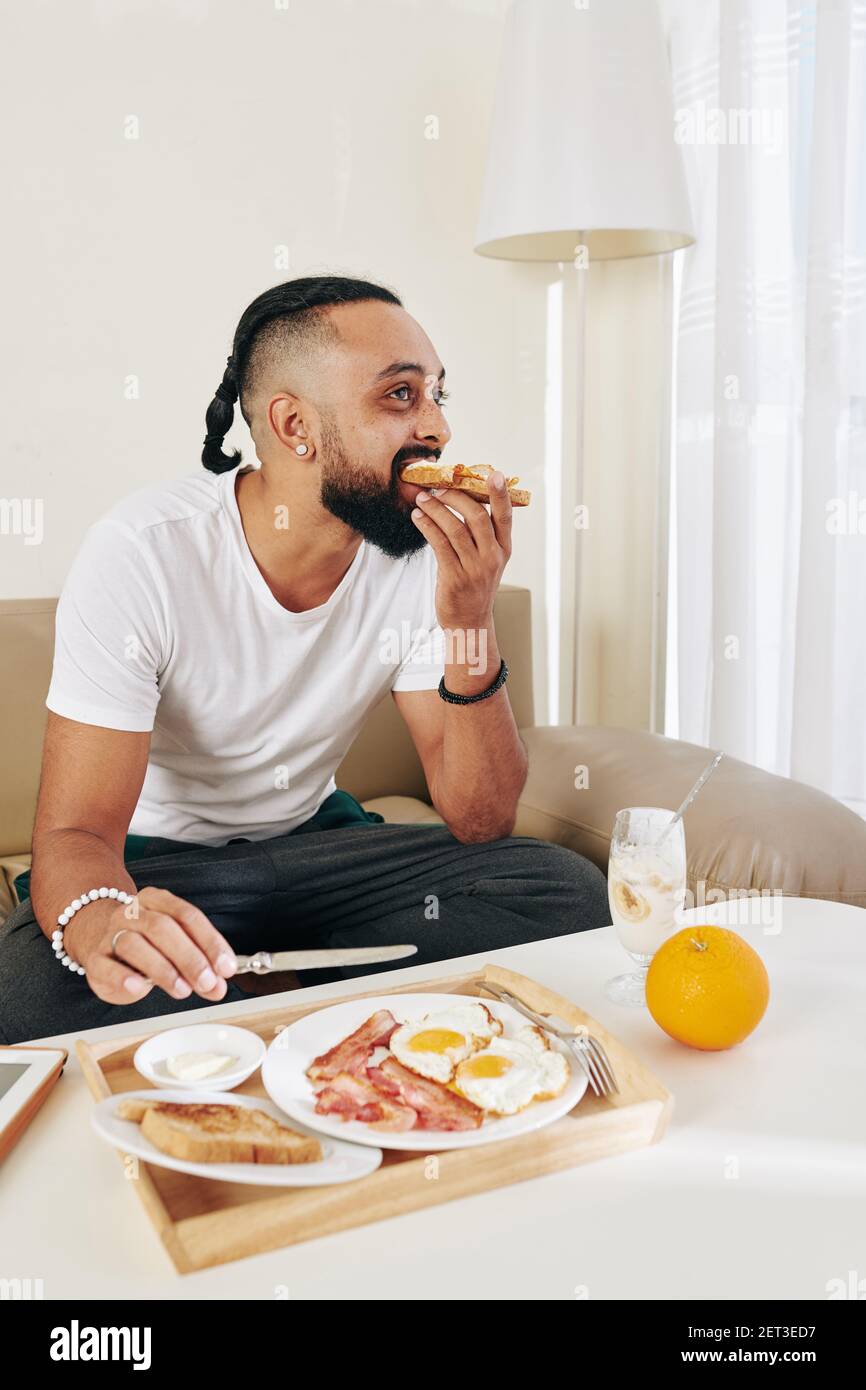 Young man eating tasty breakfast hi-res stock photography and images ...