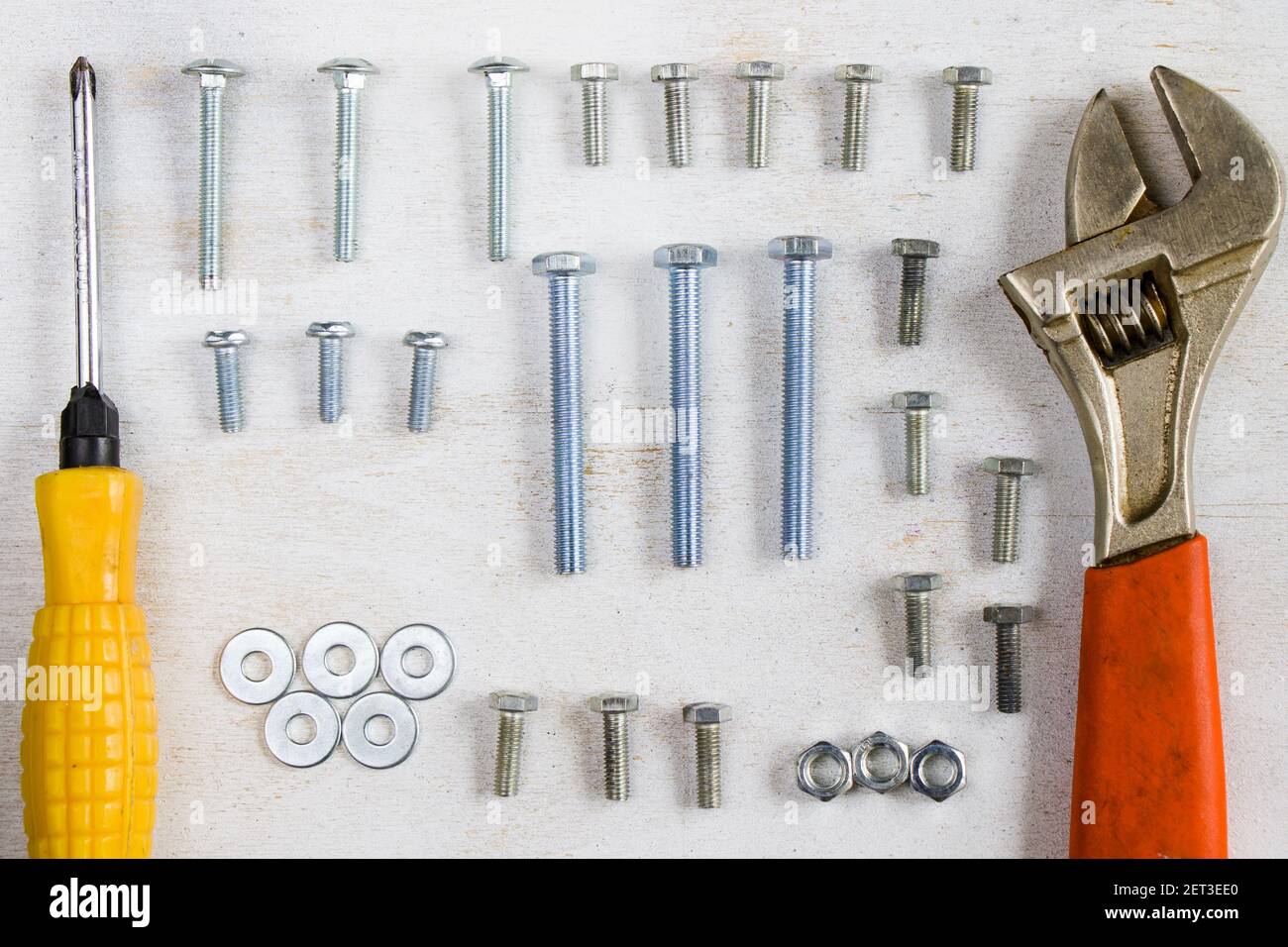 A top view of a monkey wrench, screw, bolts, and on a white background ...