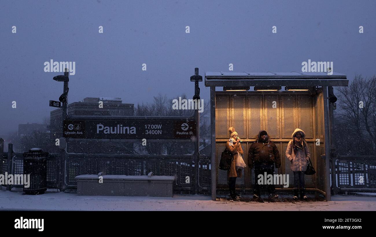 Commuters wait underneath heat lamps for a CTA Brown Line train at the ...