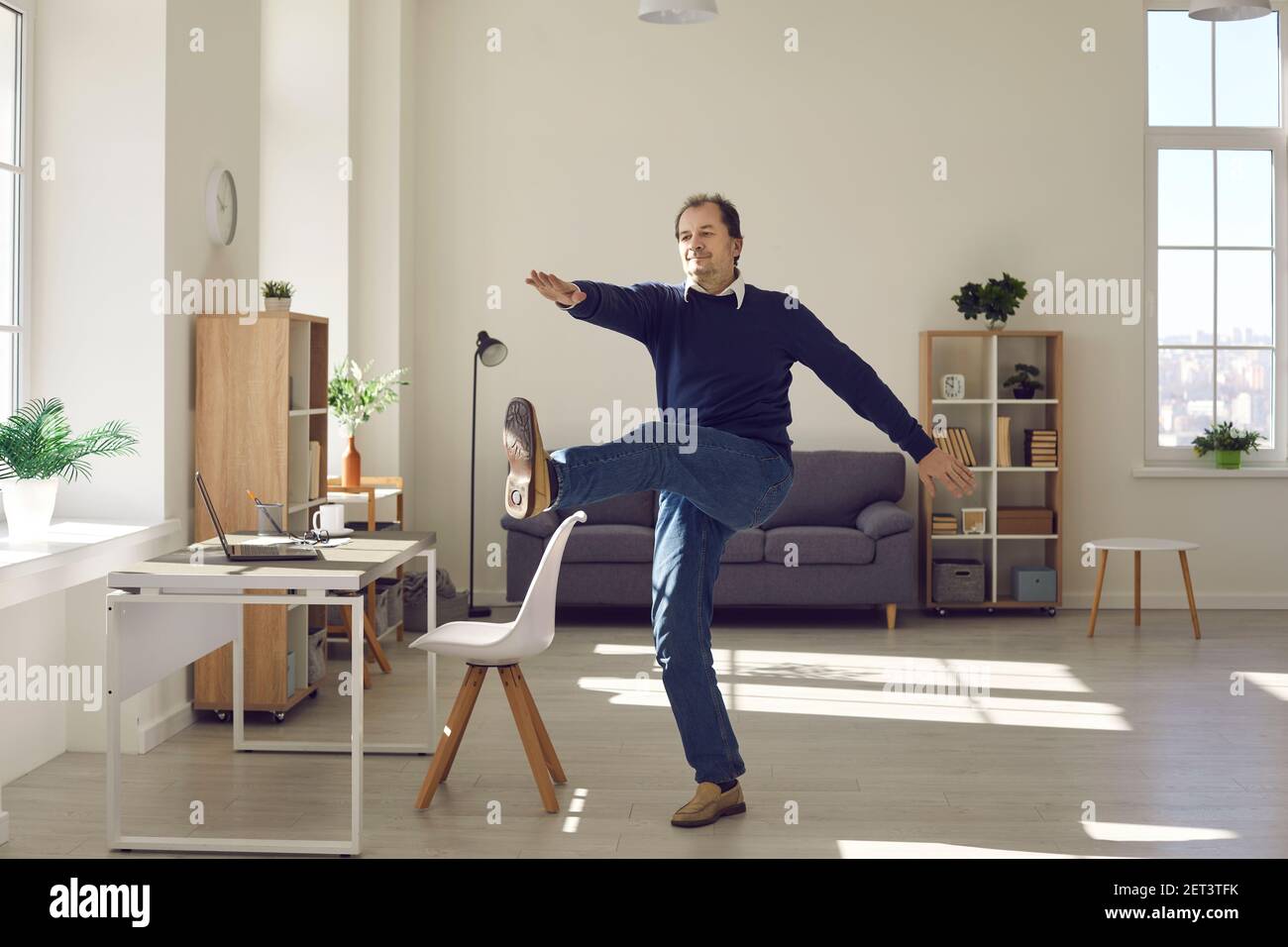 Mature businessman doing fitness exercise during working day in office ...