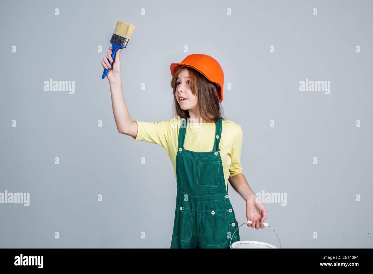 she needs little break. painter on use working tools. girl in helmet ...