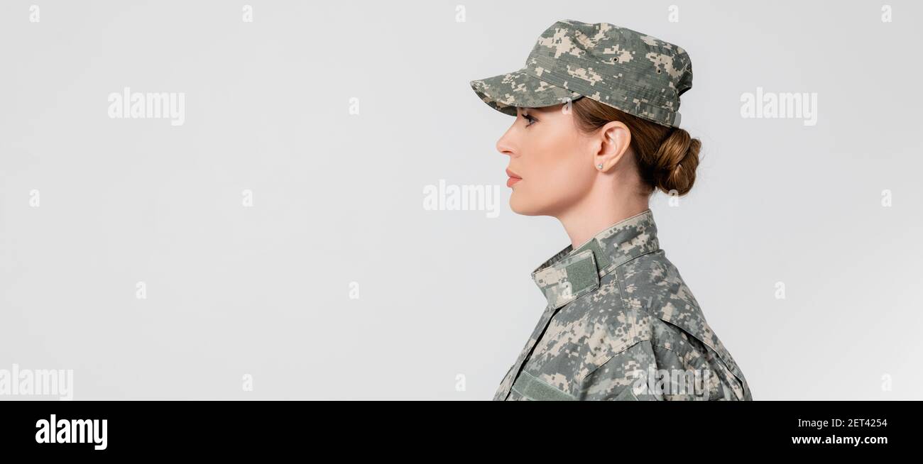 Side view of woman in military uniform looking away isolated on grey ...
